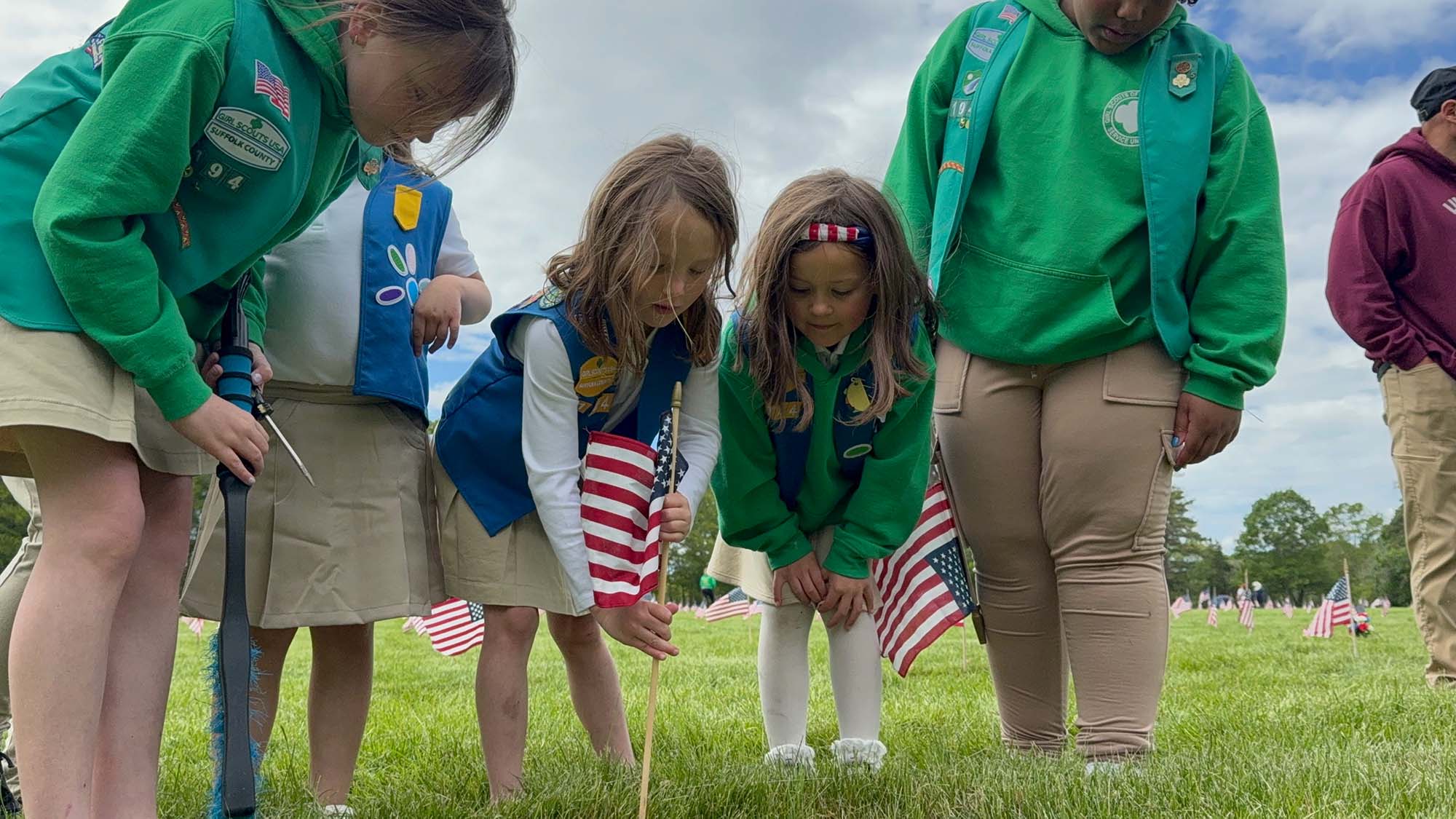 Girl Scouts plant flags at veterans’ graves during Memorial Day ...